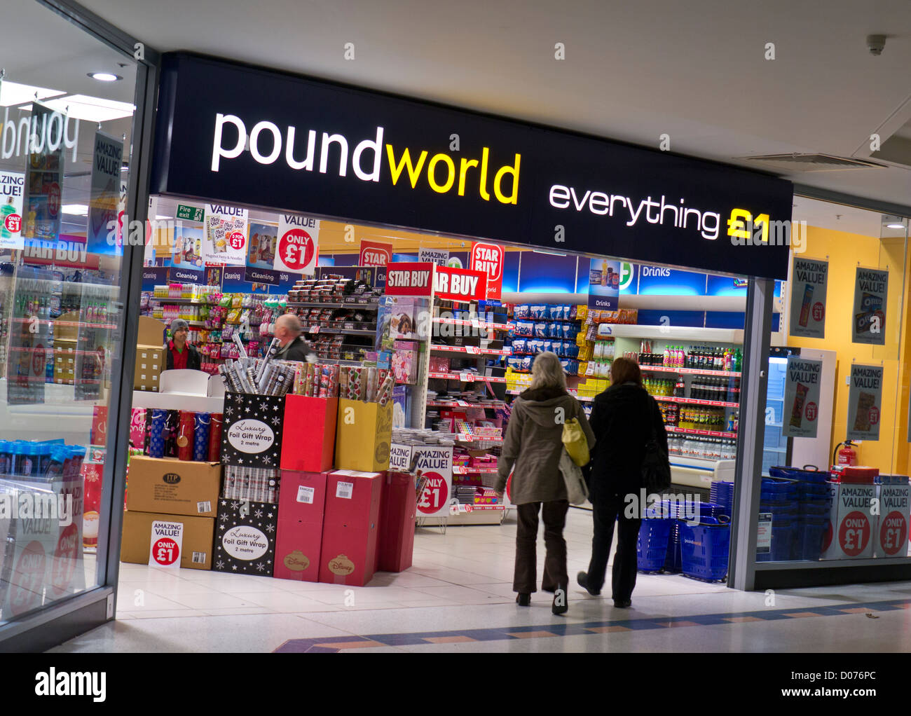 Female shopping couple entering a Poundworld shop in shopping mall ...