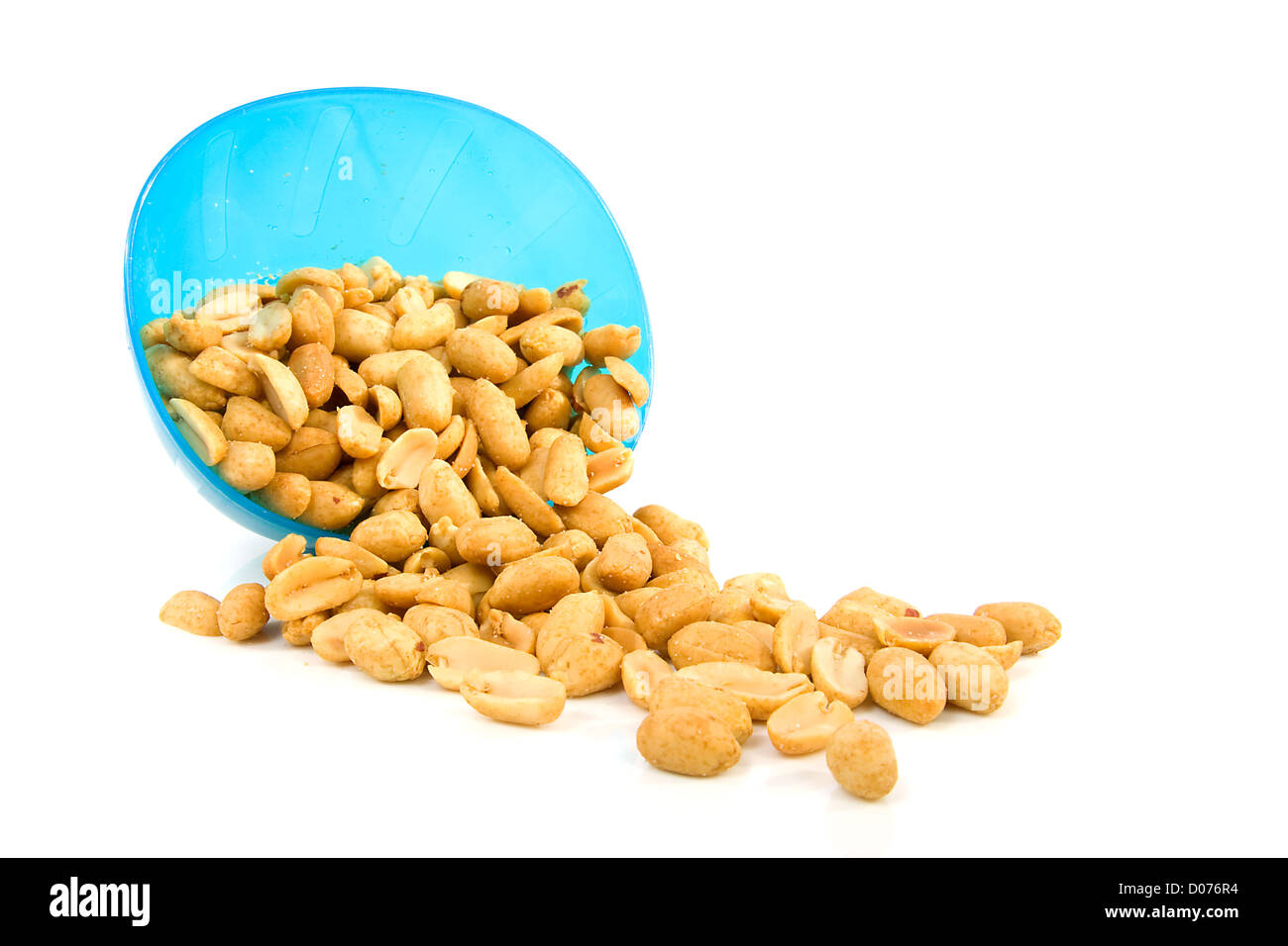 Salted peanuts falling out of blue bowl over white background Stock ...