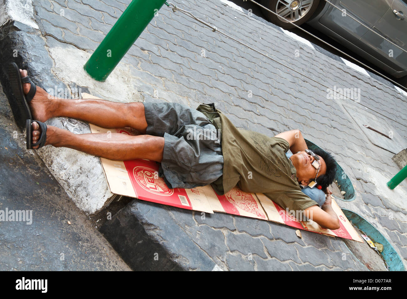 Homeless Man sleeping on a Sidewalk in Bangkok, Thailand Stock Photo ...
