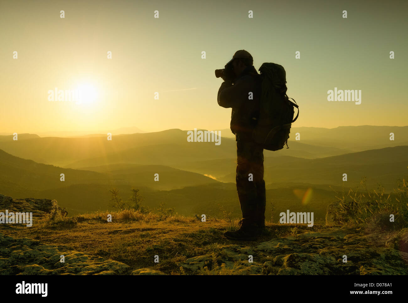 Photographer in mountains, high contrast, warm toned Stock Photo - Alamy