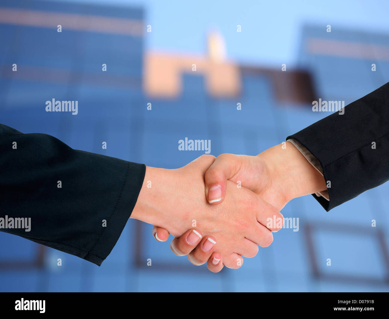 Handshake Handshaking and blured building in background Stock Photo - Alamy
