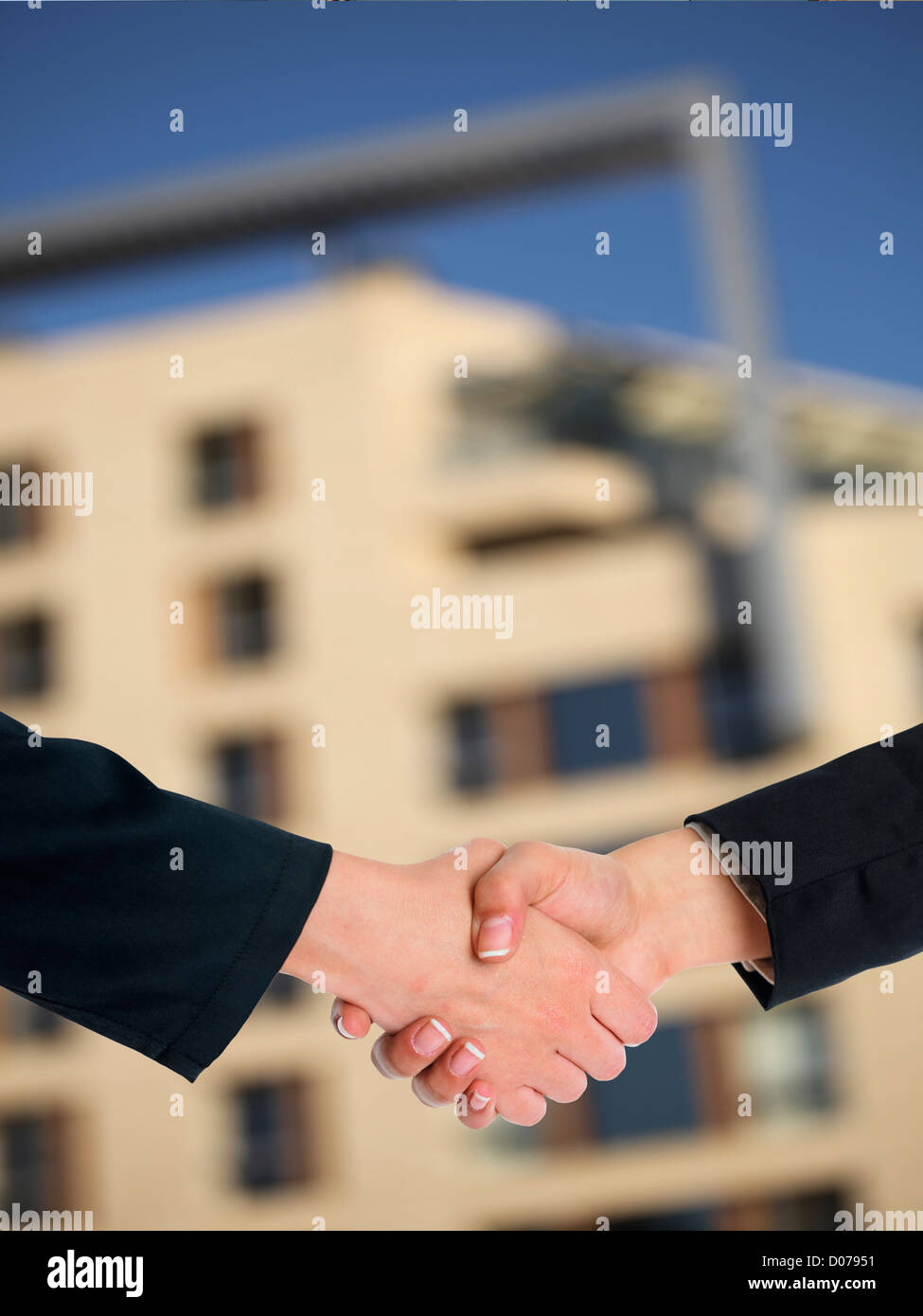 Handshake Handshaking and blured building in background Stock Photo - Alamy
