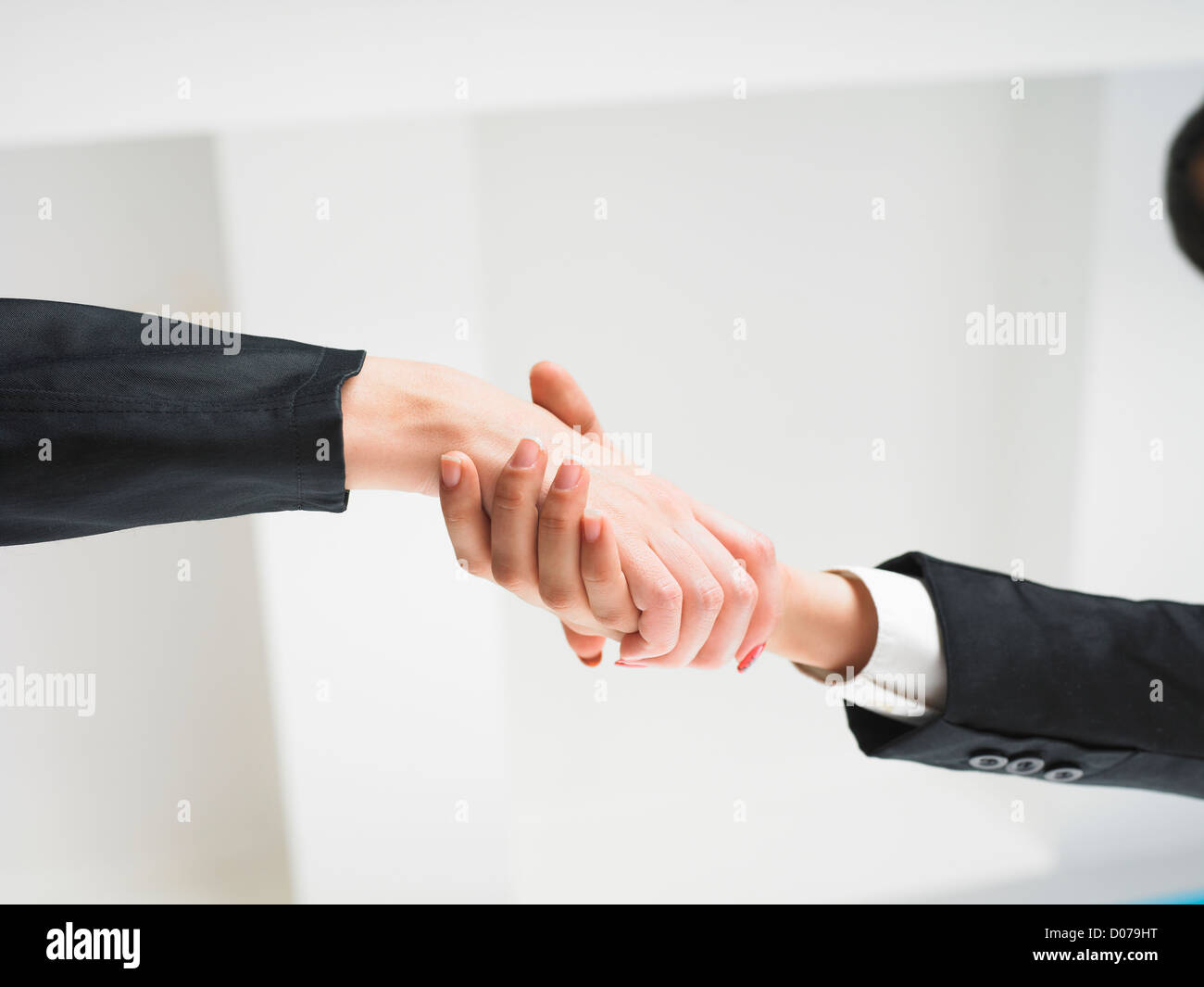Handshaking in office low angle Stock Photo - Alamy