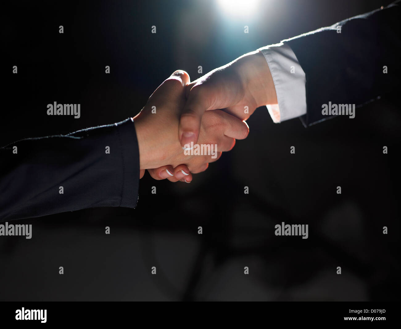 Handshake Handshaking on light and dark Stock Photo - Alamy
