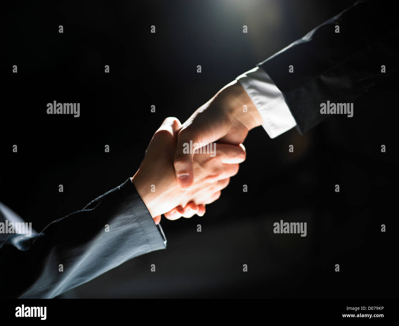 Handshake Handshaking light and dark Stock Photo - Alamy