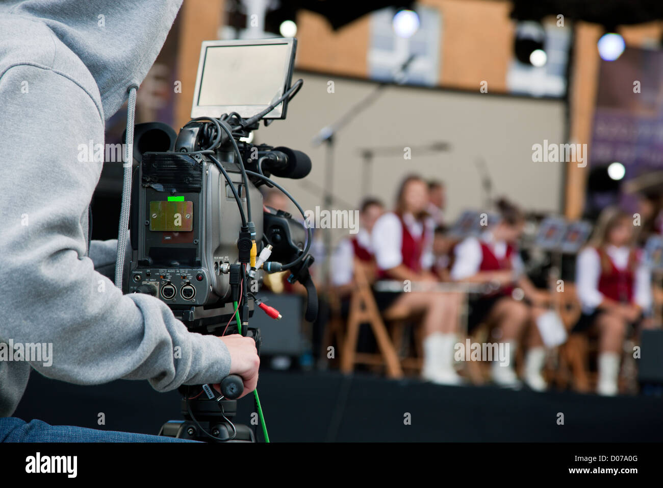 Video camera operator capturing performance on stage Stock Photo - Alamy