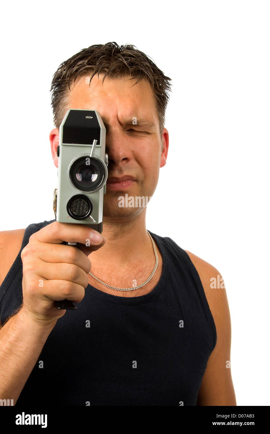 man is filming with old fashioned film camera over white background ...