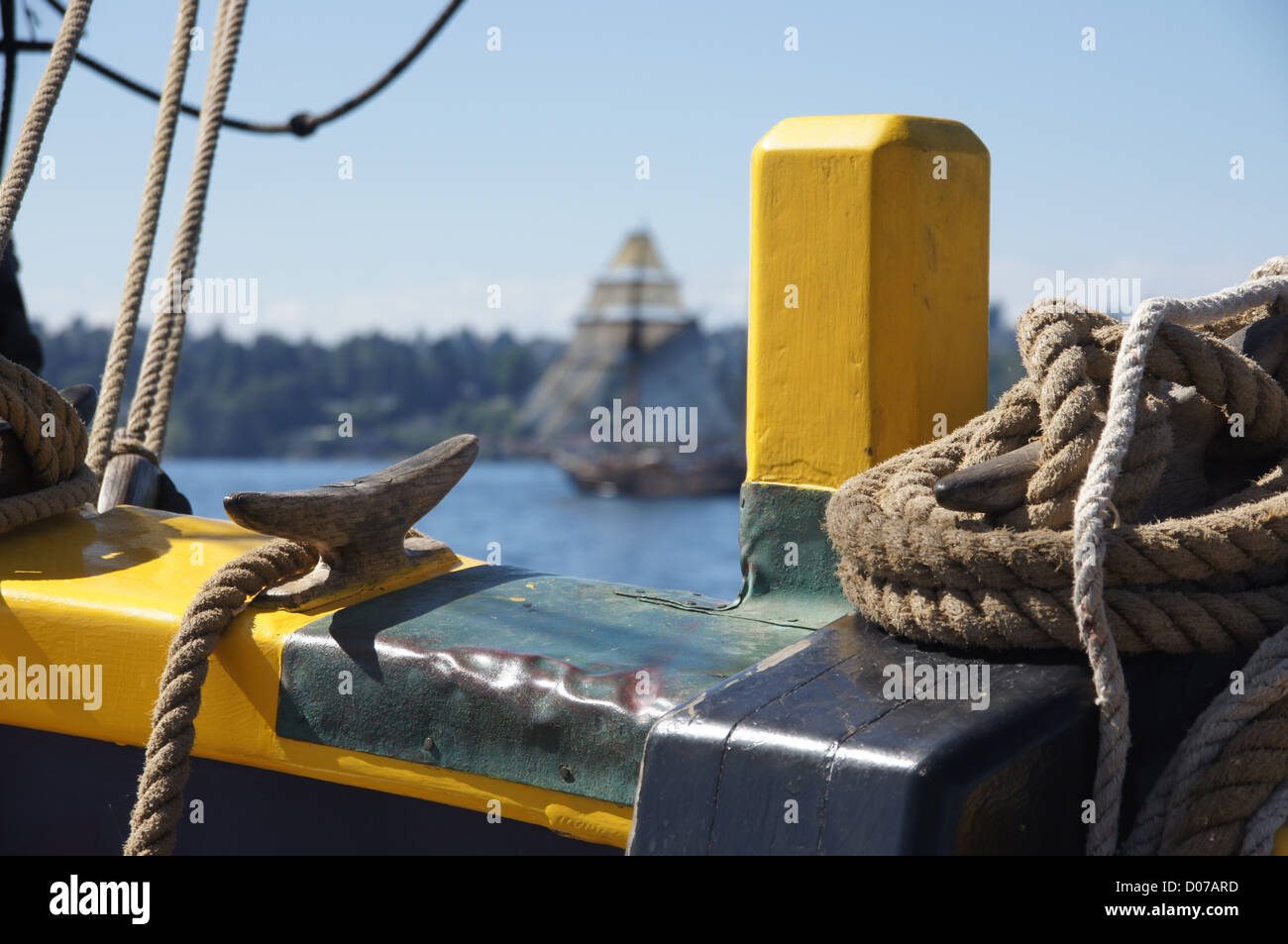 Bulwark and coiled rope with tall ship sailing in background near ...