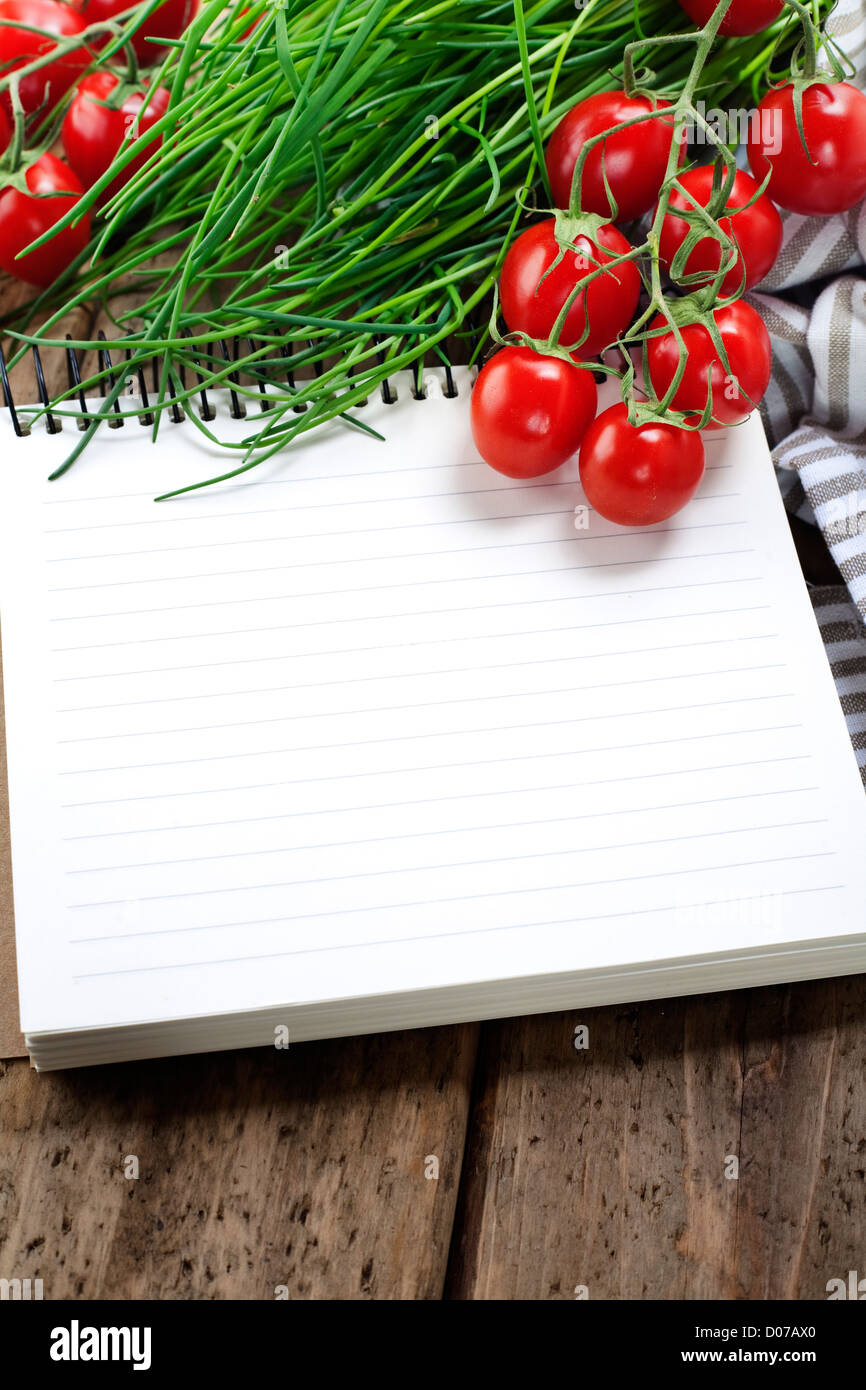 Open notebook (or empty cookbook ready for recipe) and fresh vegetables ...