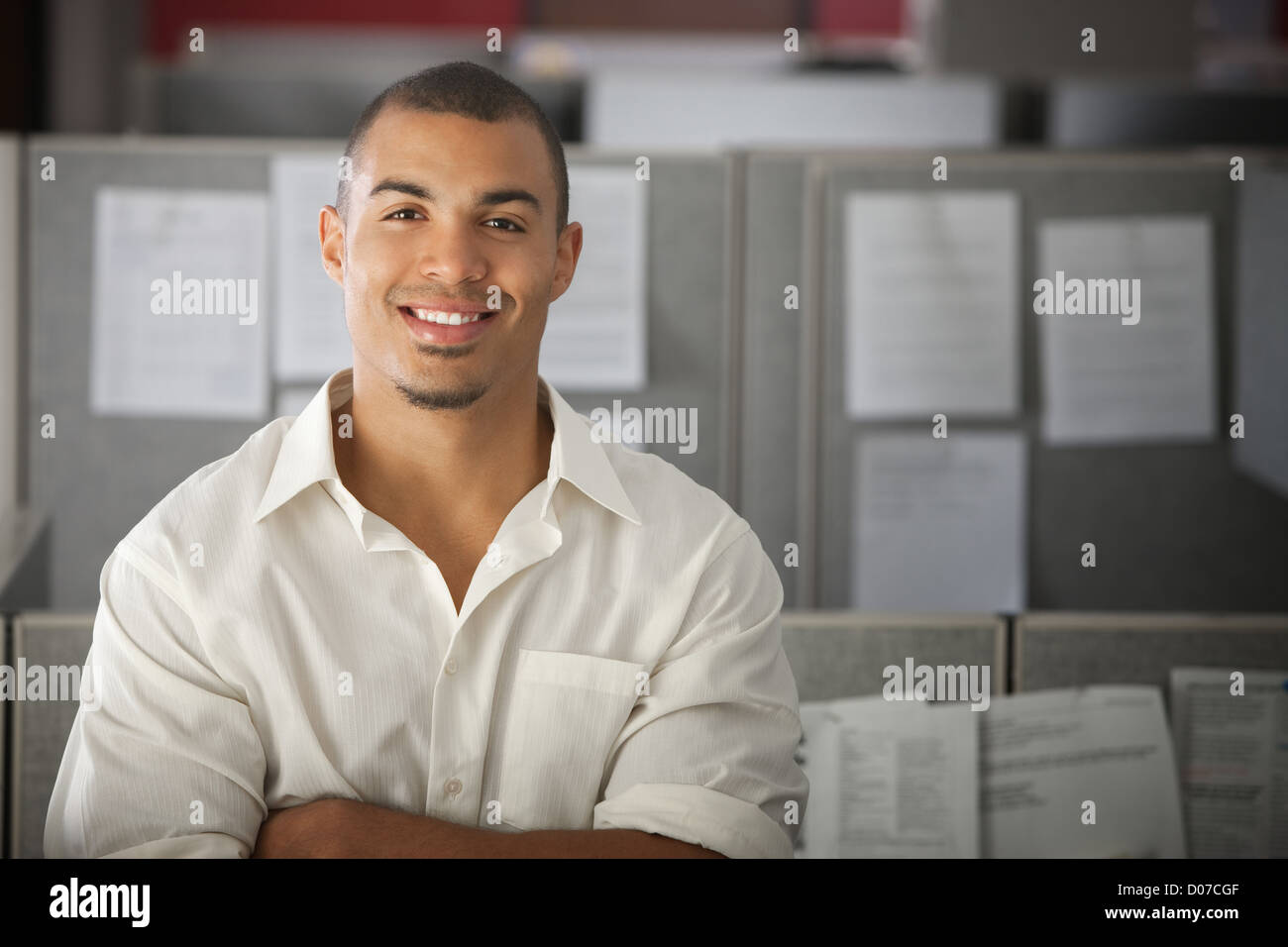Confident office worker smiles in his office cubicle Stock Photo - Alamy