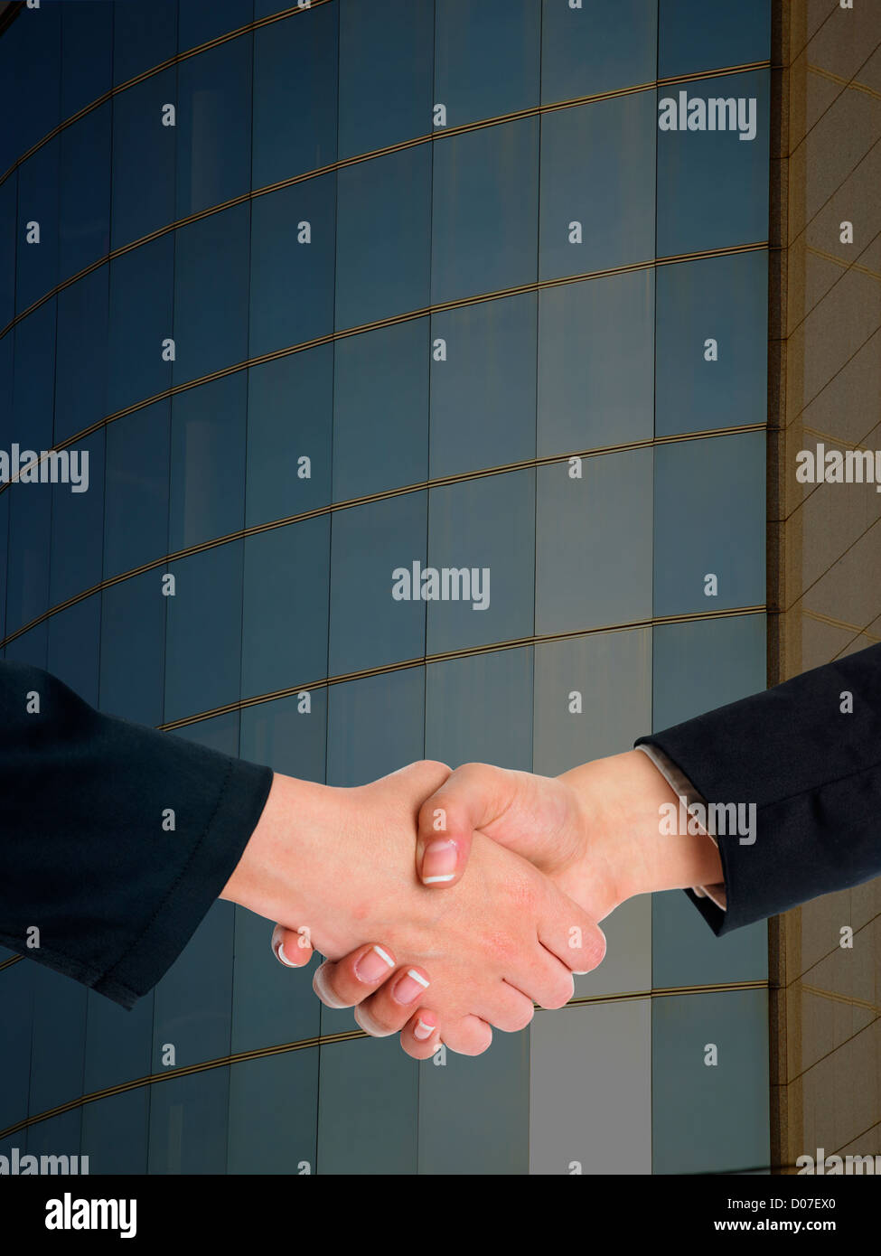 Handshake Handshaking and blured building in background Stock Photo - Alamy