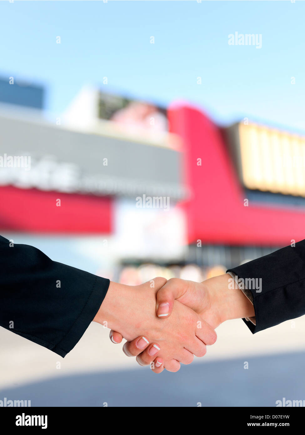 Handshake Handshaking and blured building in background Stock Photo - Alamy