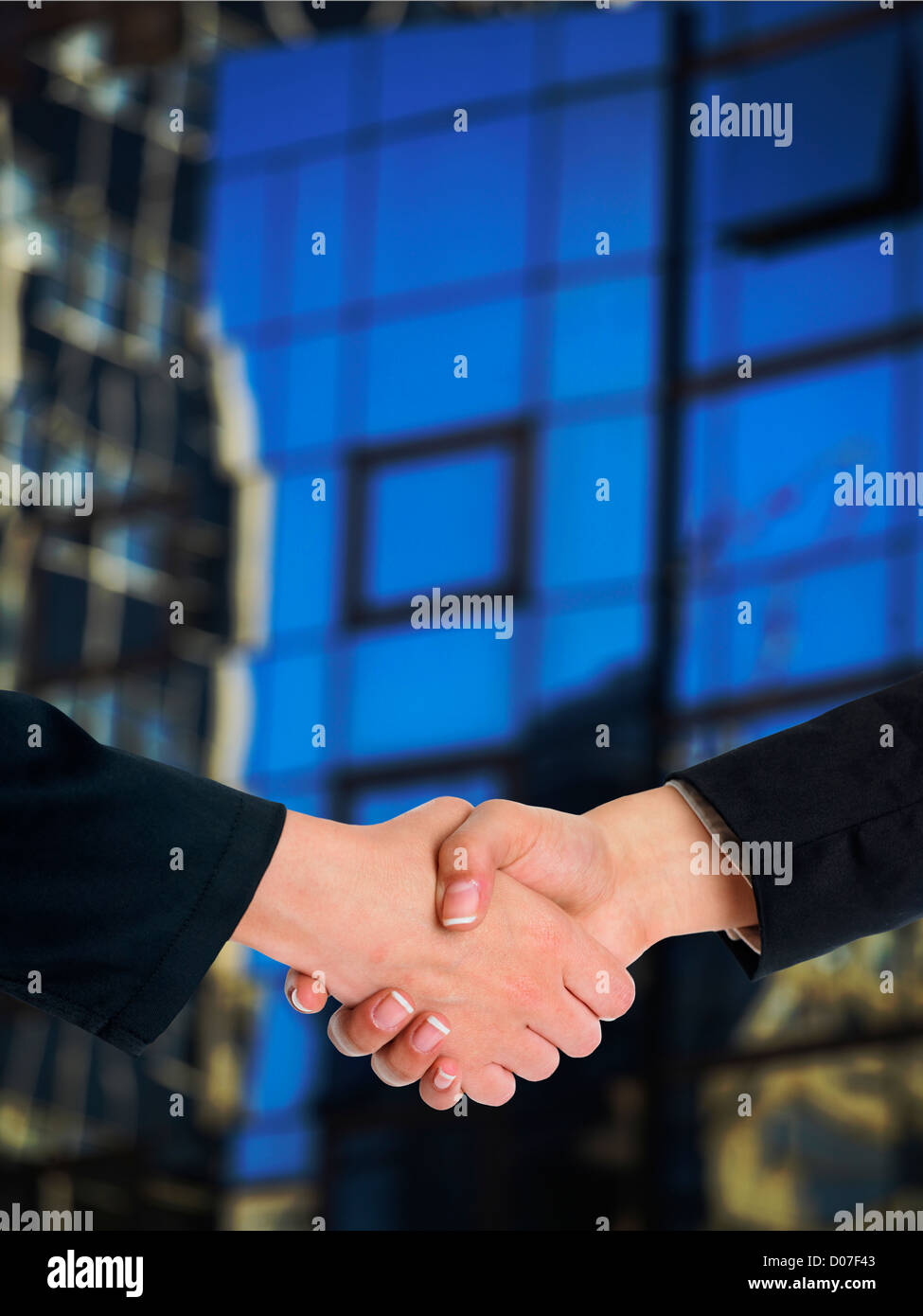 Handshake Handshaking and blured building in background Stock Photo - Alamy