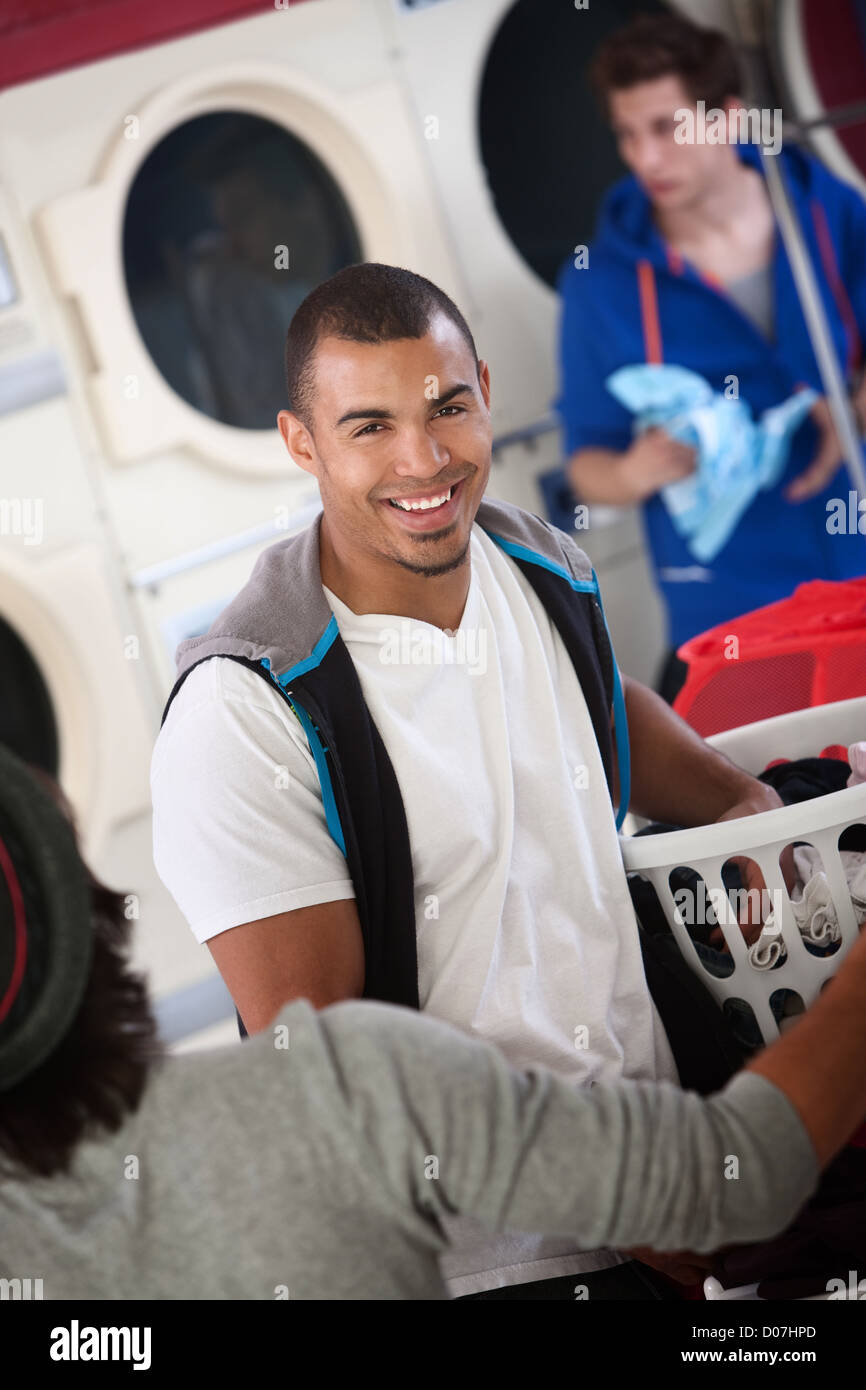 Young muscular Latino man smiles in laundromat Stock Photo - Alamy