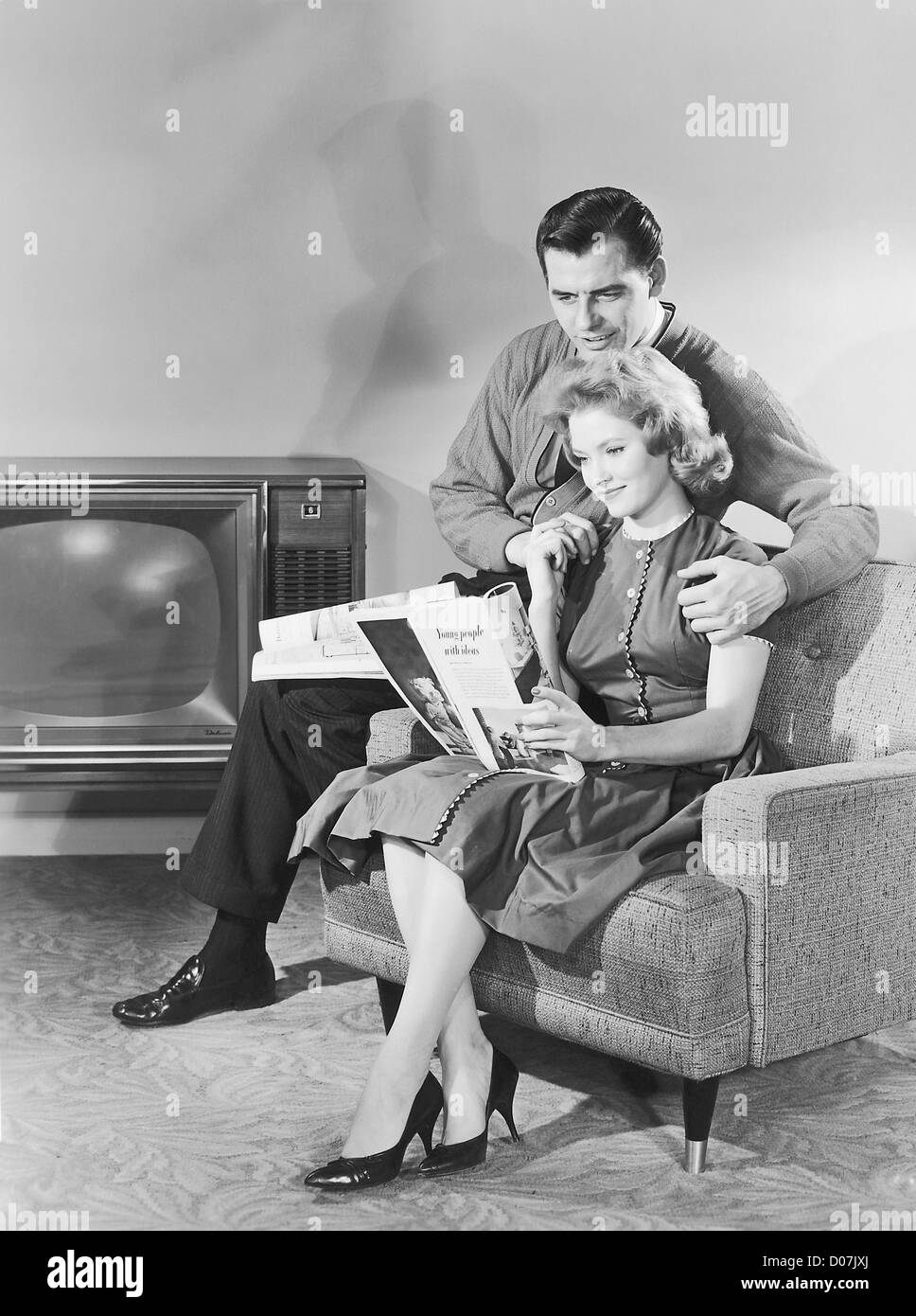 Couple looking at a magazine together Stock Photo - Alamy