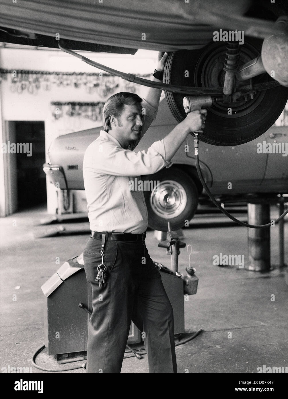 Worker fixing car wheel Stock Photo - Alamy