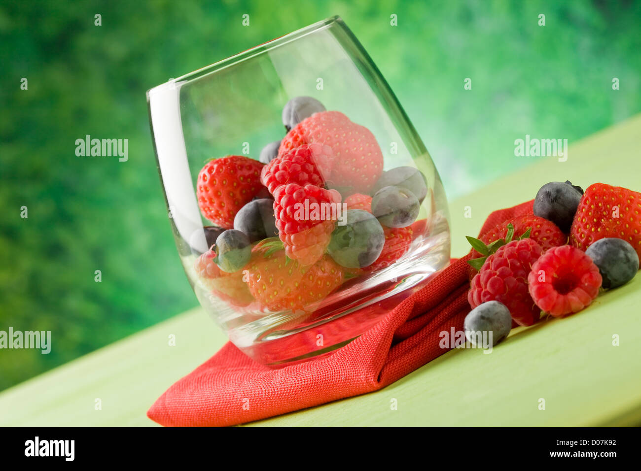 photo of delicious berries inside a crystal glass in front of green ...