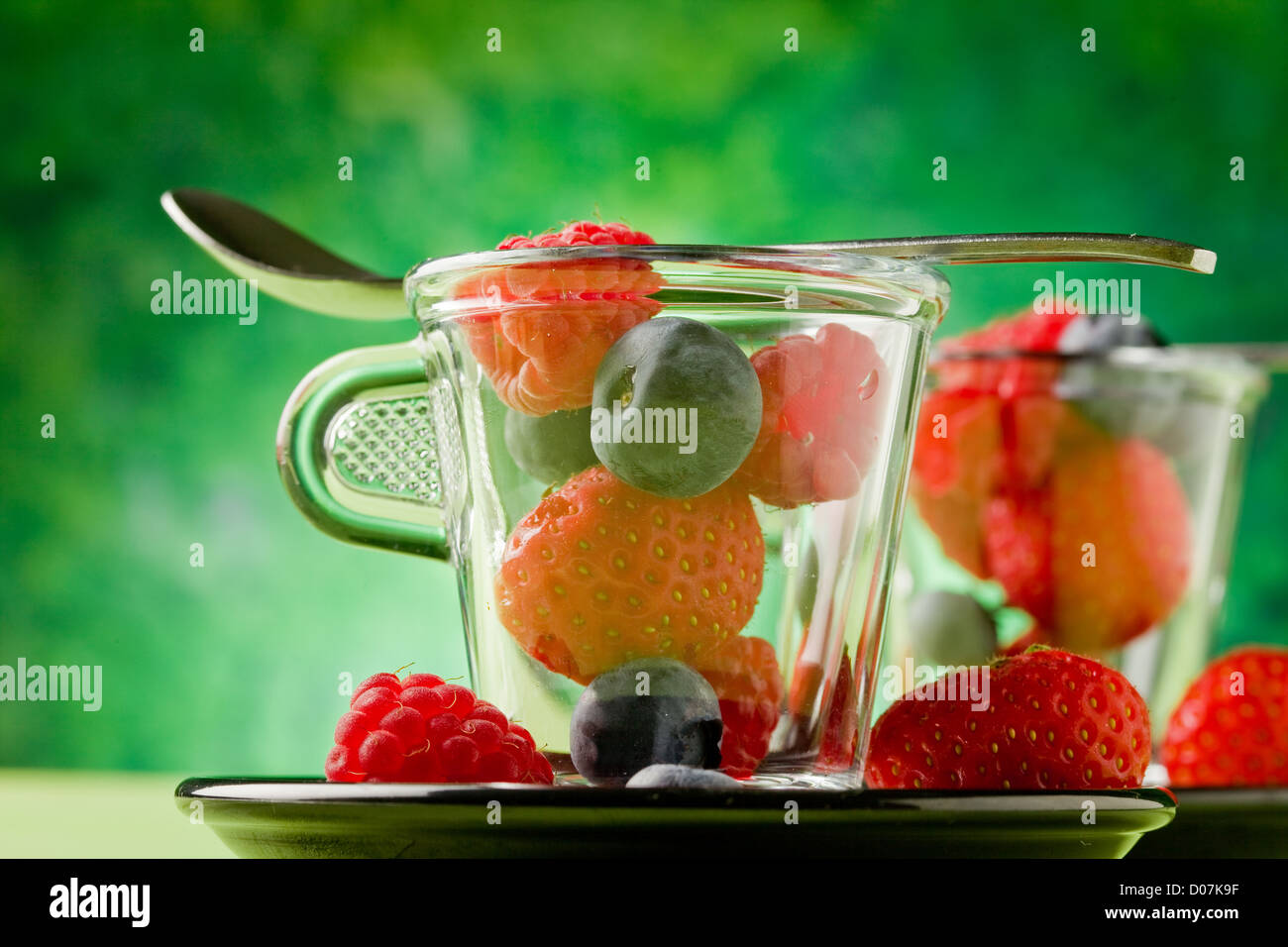 photo of delicious berries inside a glass cup with green background ...