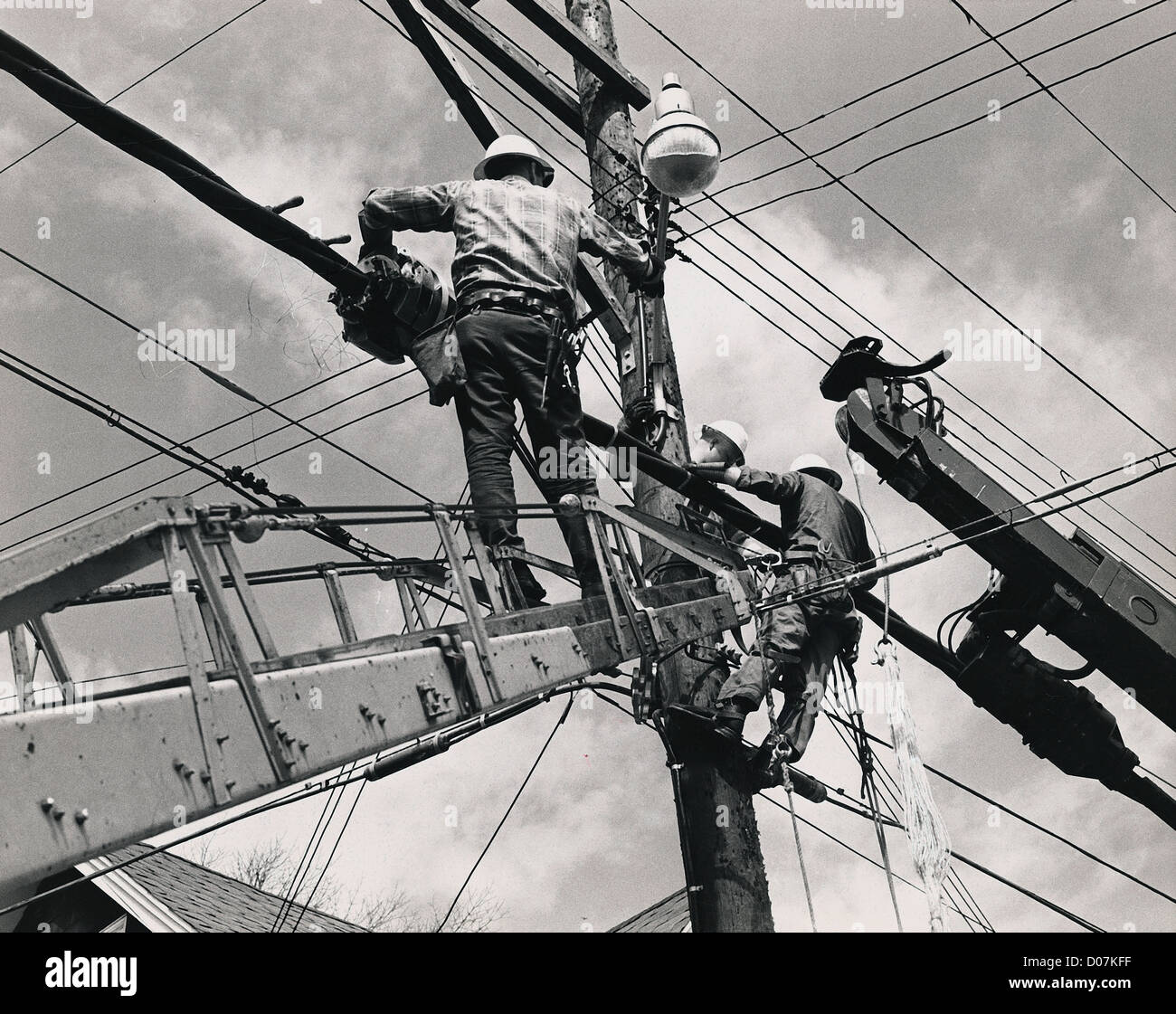 Workers fixing electric cable Stock Photo - Alamy