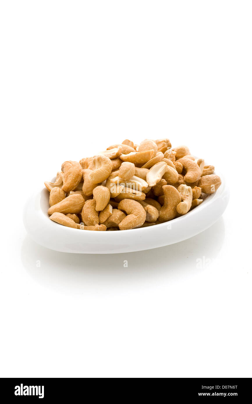 photo of delicious cashews inside a plate on white isoalted background ...