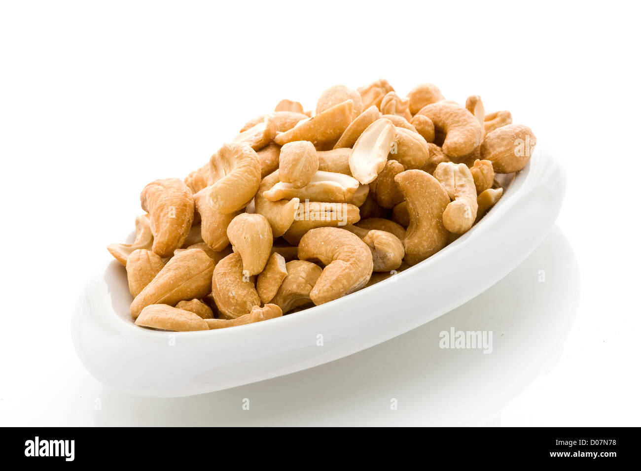 photo of delicious cashews inside a plate on white isoalted background ...