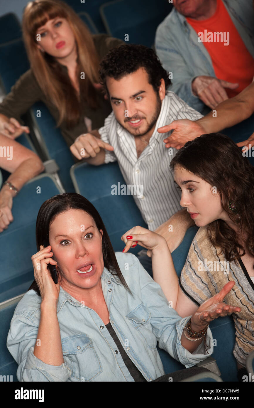 Loud woman on phone frustrates audience in theater Stock Photo - Alamy