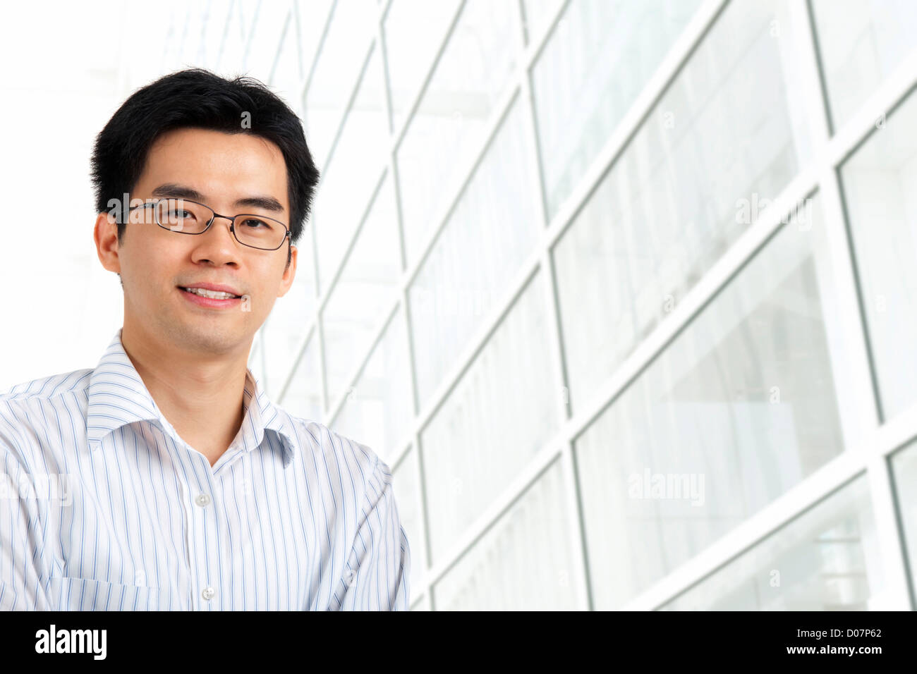 Good looking Asian executive standing outside office building Stock ...