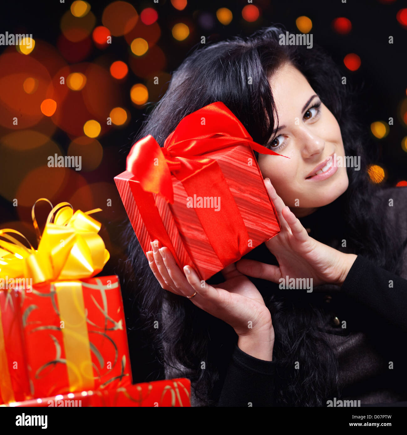 Cute woman with presents at night holiday celebration Stock Photo - Alamy