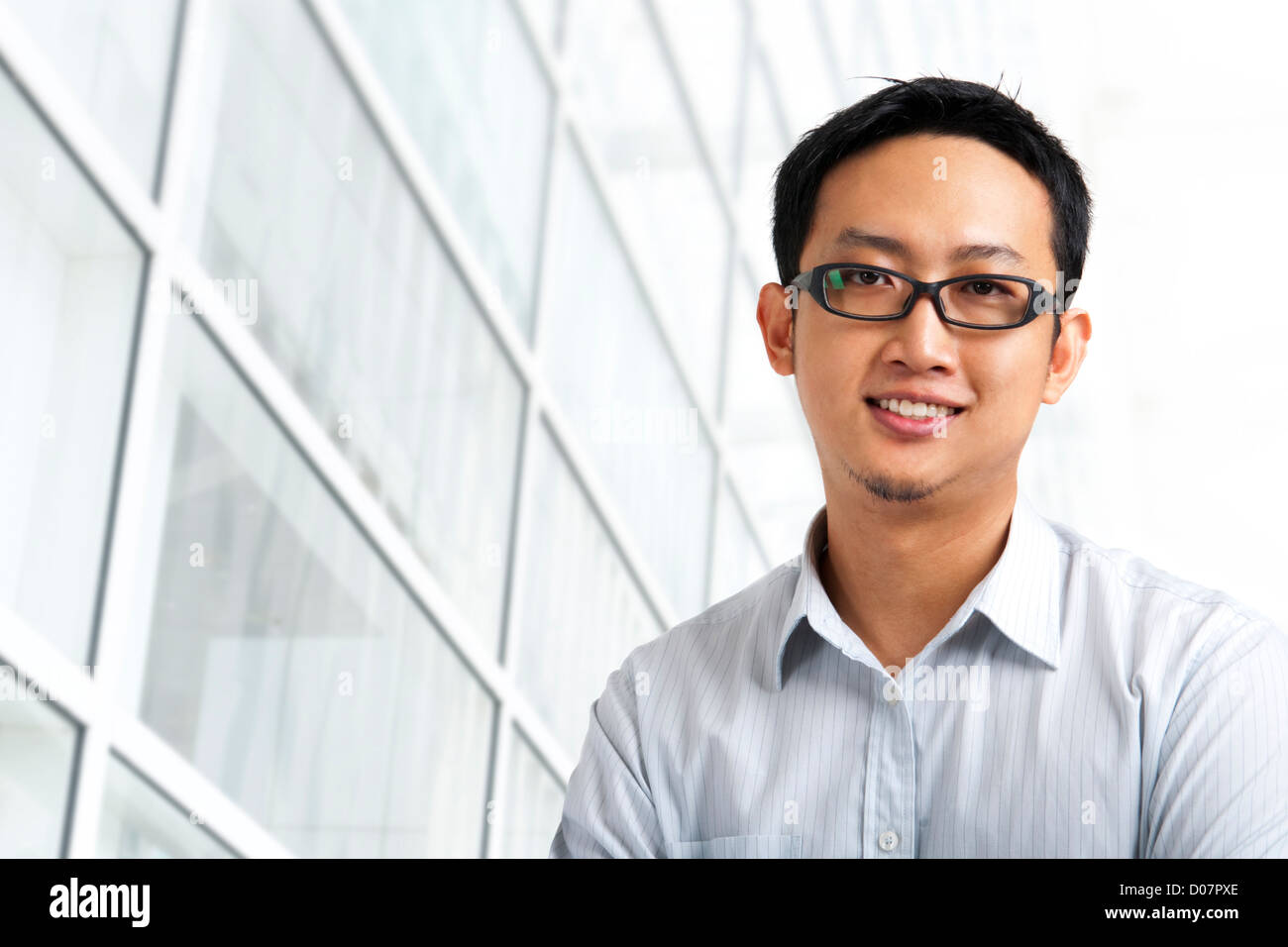 Good looking Asian standing outside office building Stock Photo - Alamy