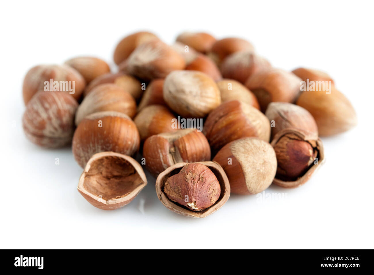 Closeup of whole and cracked hazelnuts. Isolated on white background ...