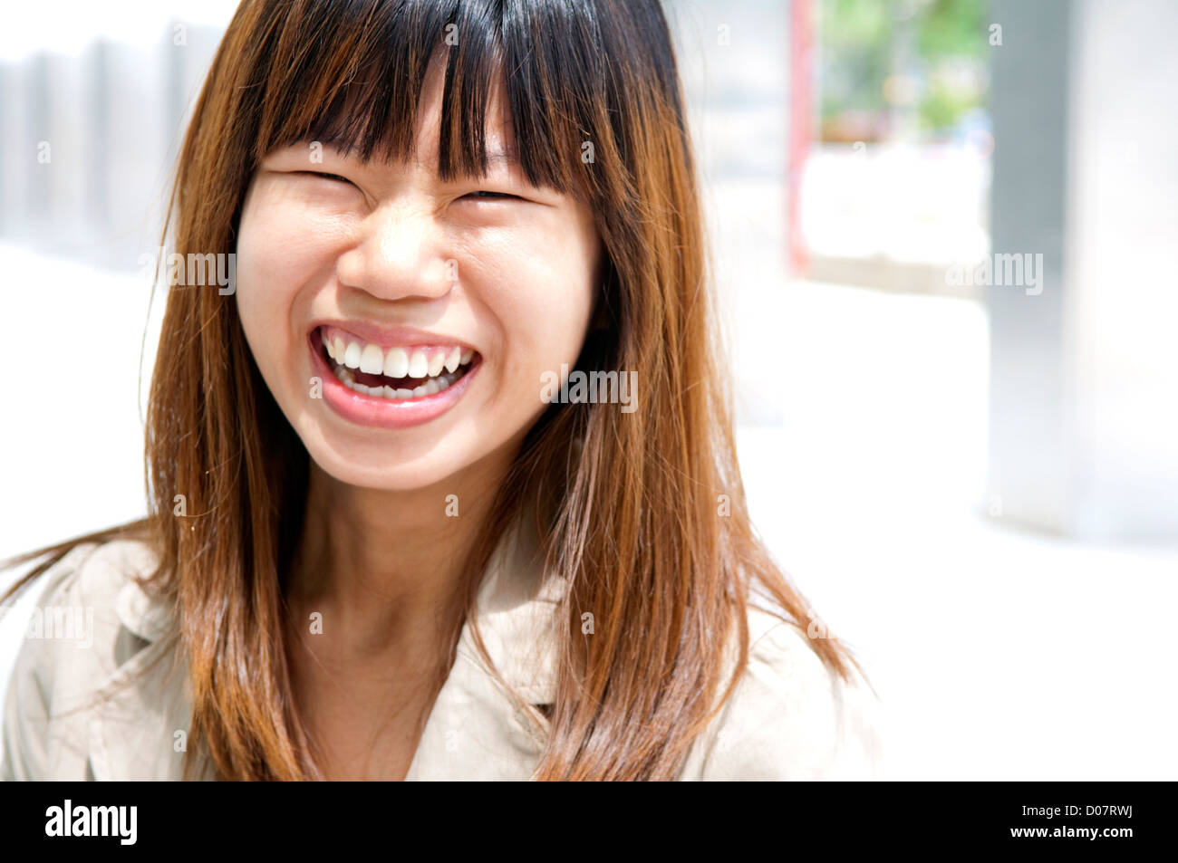 Asian female with her cheerful smile, outside modern building Stock ...