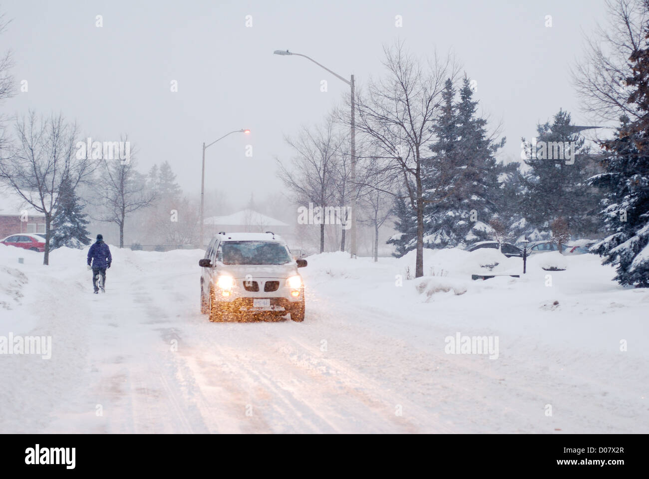 Pedestrian and car in a snow blizzard Stock Photo - Alamy