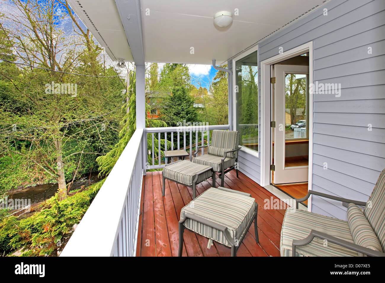 Balcony house exterior with outdoor furniture and view of woods and ...