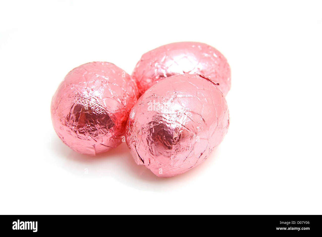 Three pink chocolate easter eggs over white background Stock Photo - Alamy