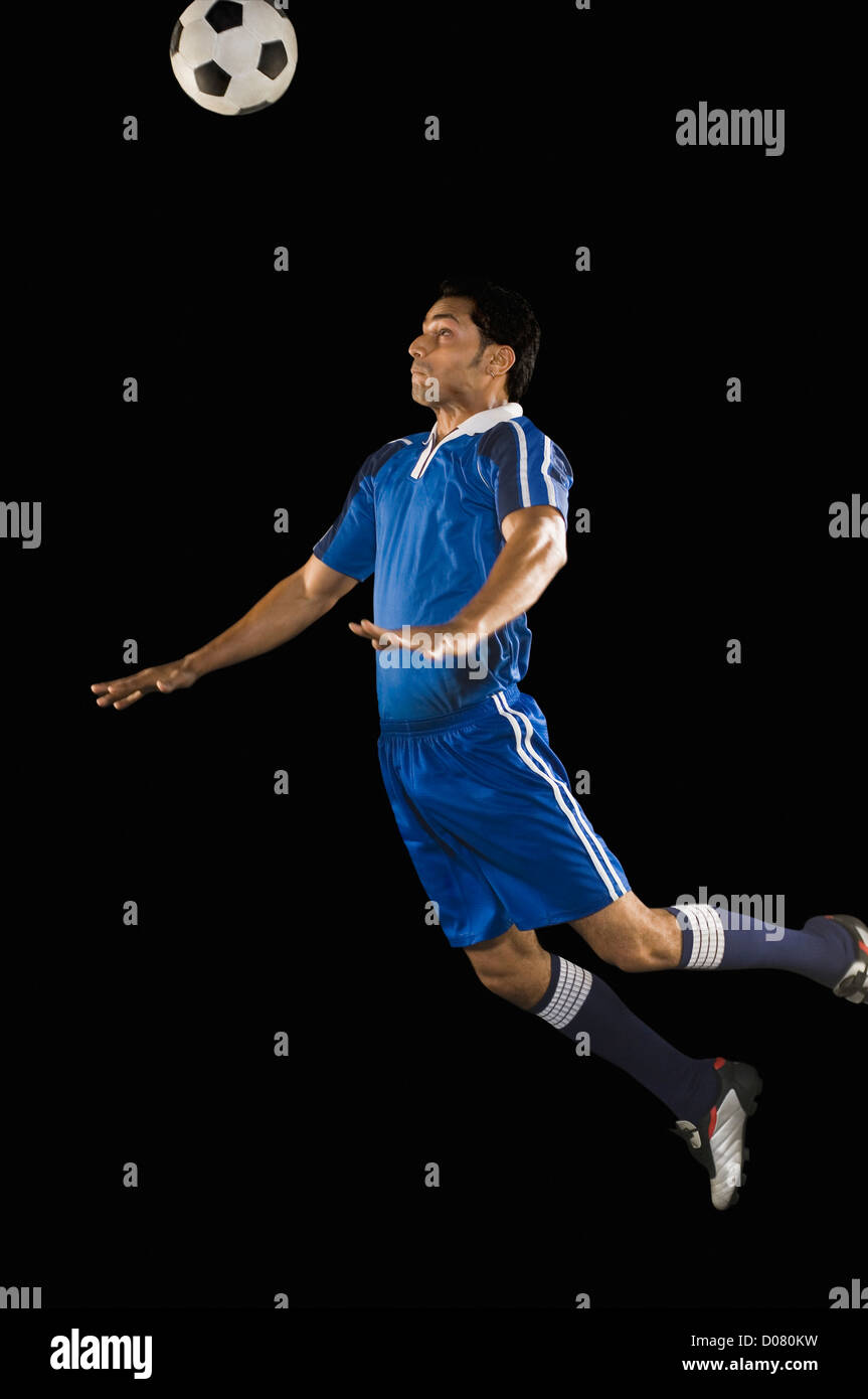 Man heading a soccer ball Stock Photo - Alamy