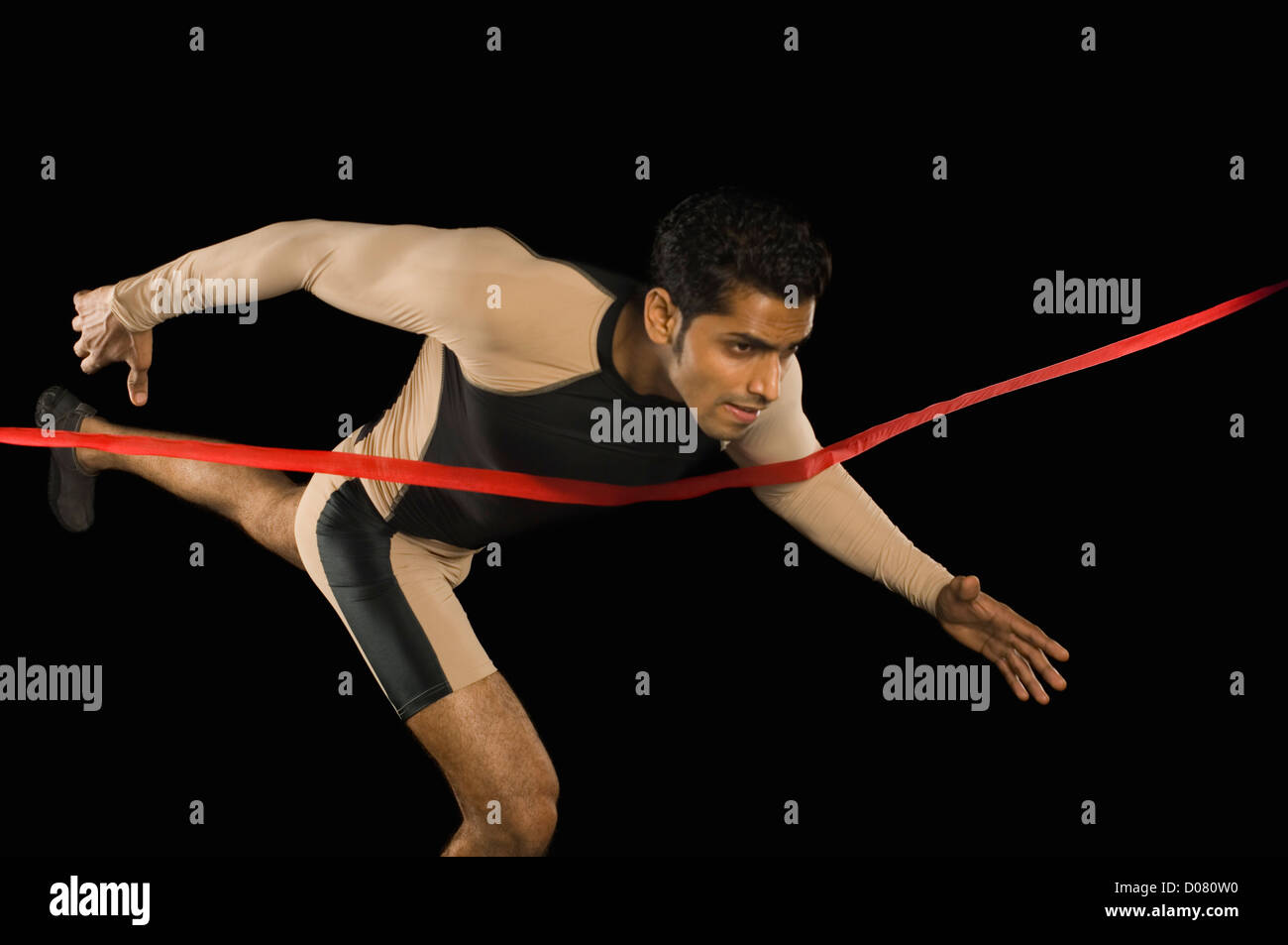 Athlete running through a finishing line Stock Photo - Alamy