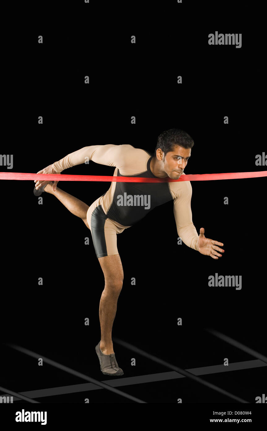 Athlete running through a finishing line Stock Photo - Alamy