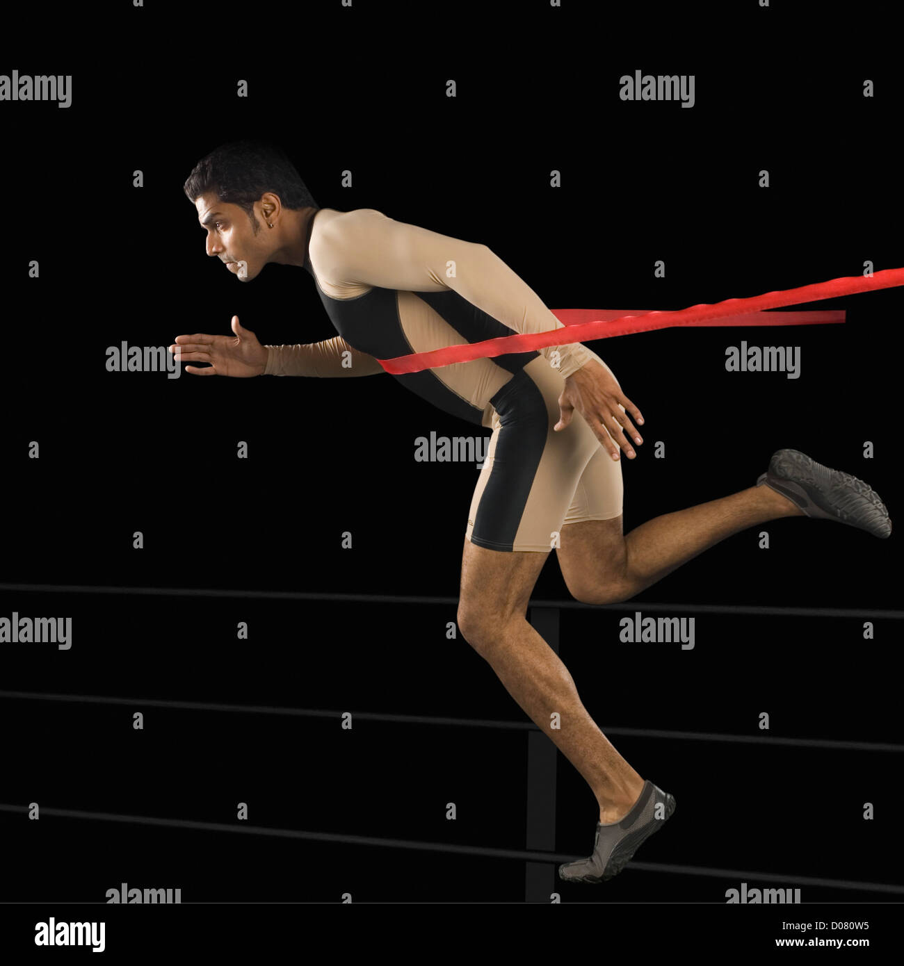 Athlete running through a finishing line Stock Photo - Alamy