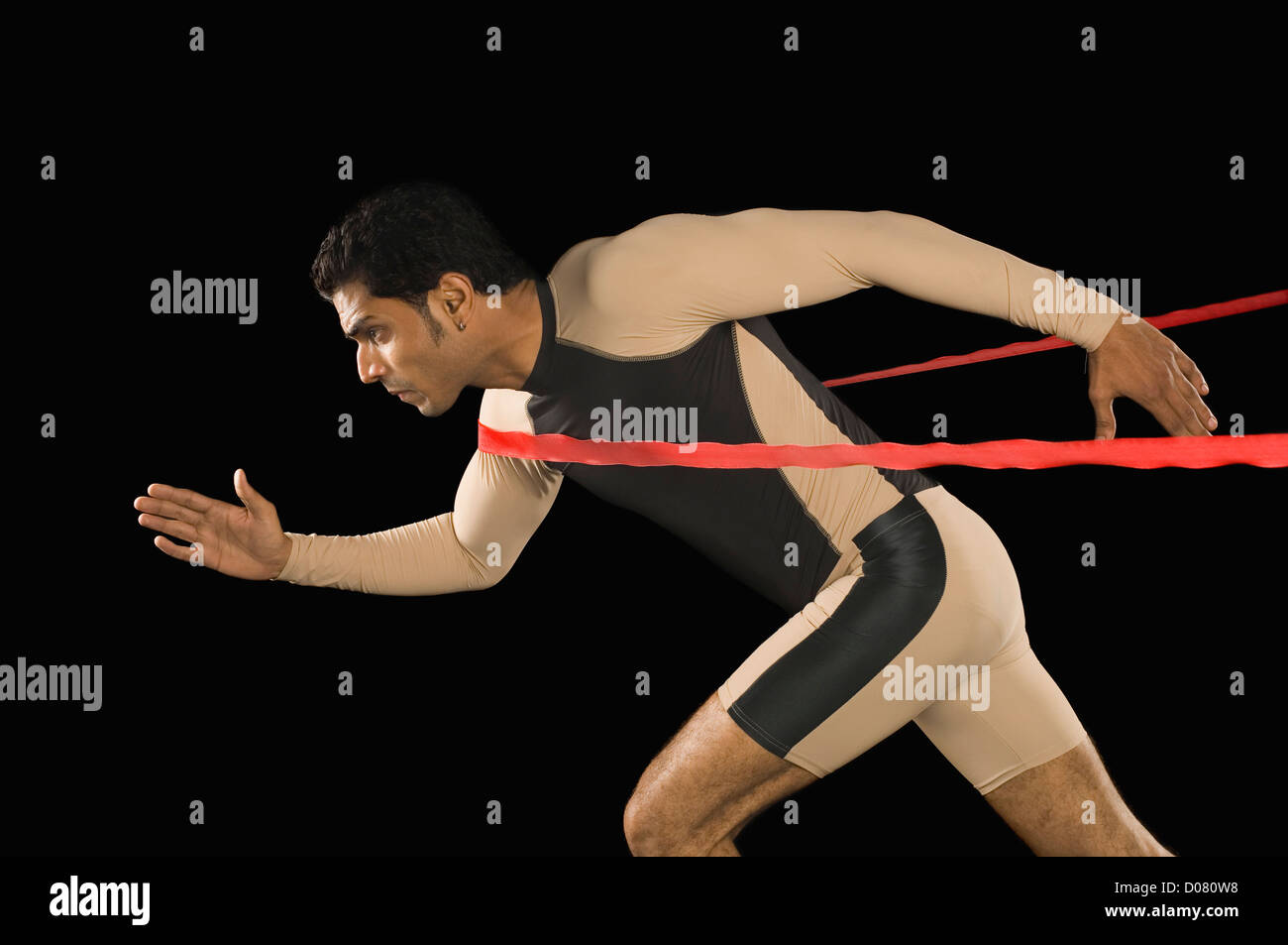 Athlete running through a finishing line Stock Photo - Alamy