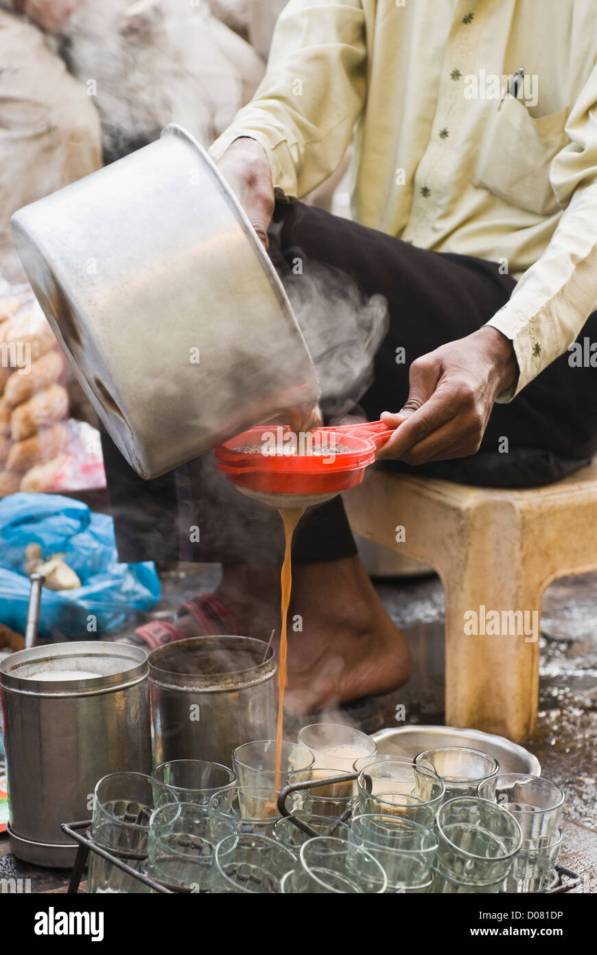 Man sieving tea into glasses, Delhi, India Stock Photo - Alamy
