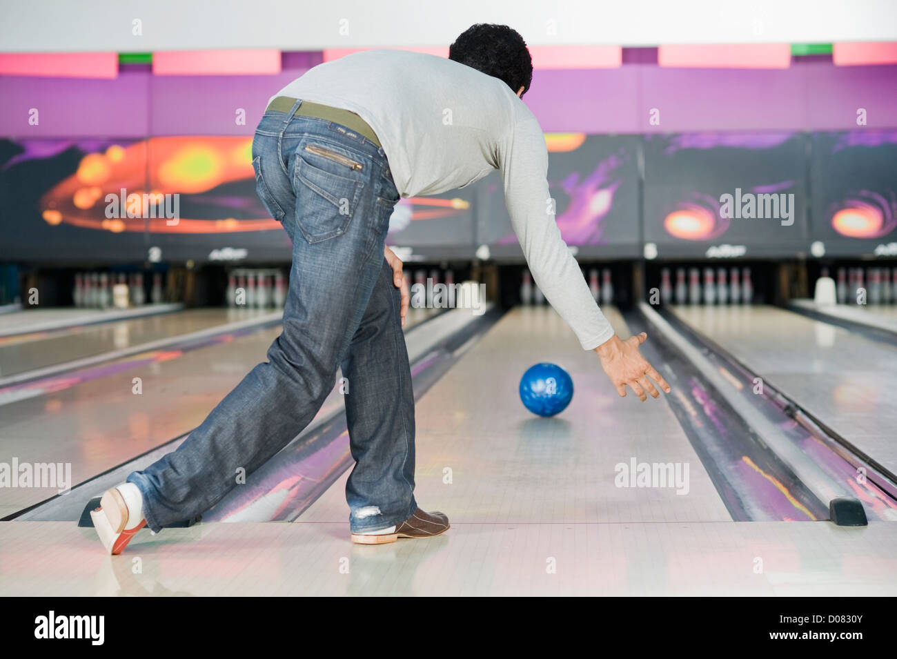 Young man playing ten pin bowling Stock Photo - Alamy