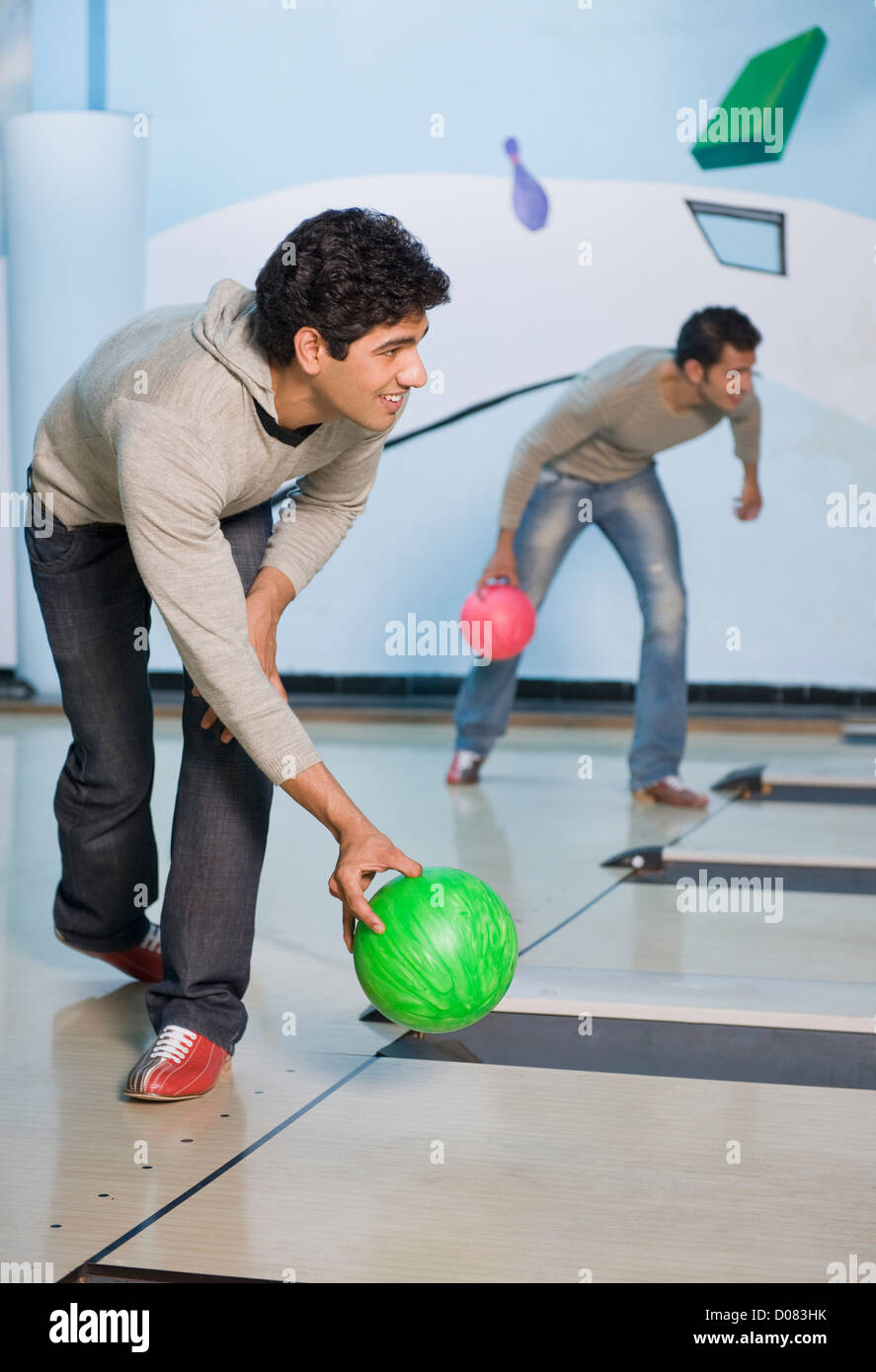 Two young men bowling in a bowling alley Stock Photo - Alamy