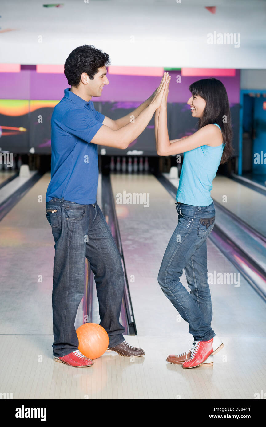 Young couple giving high-five Stock Photo - Alamy