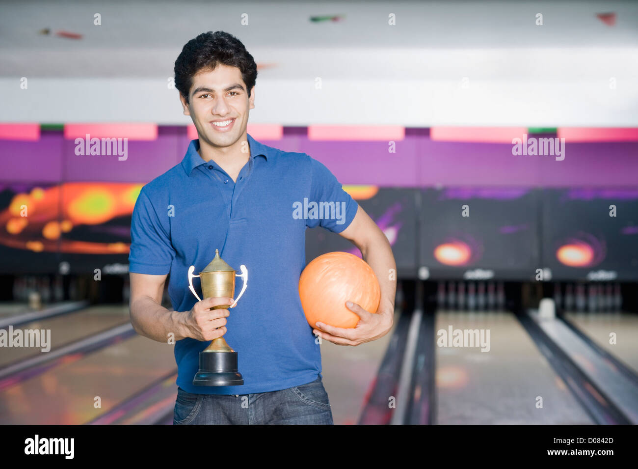 Young man holding a bowling ball in a bowling alley Stock Photo - Alamy