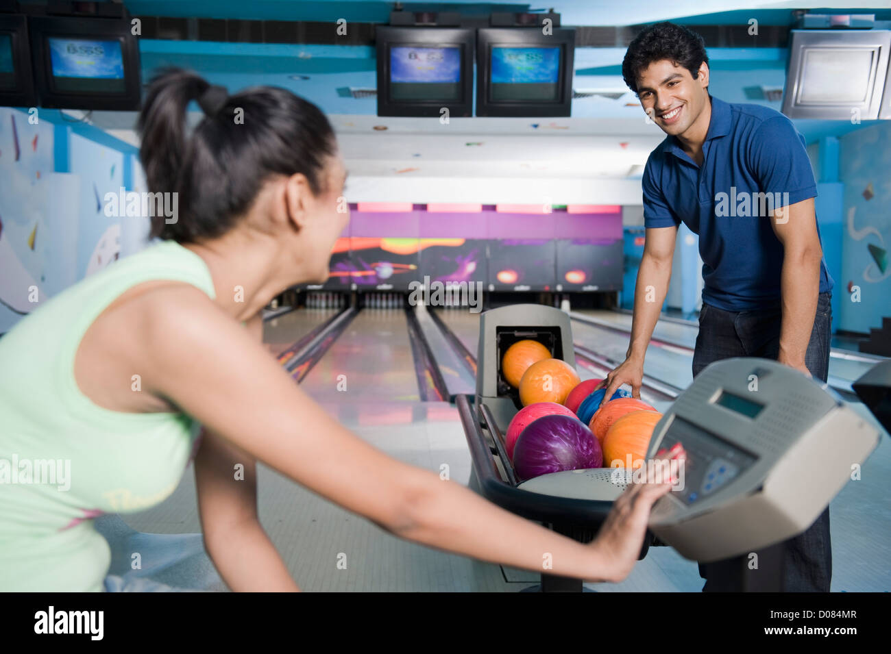 Young woman operating the control panel and her friends looking at her ...