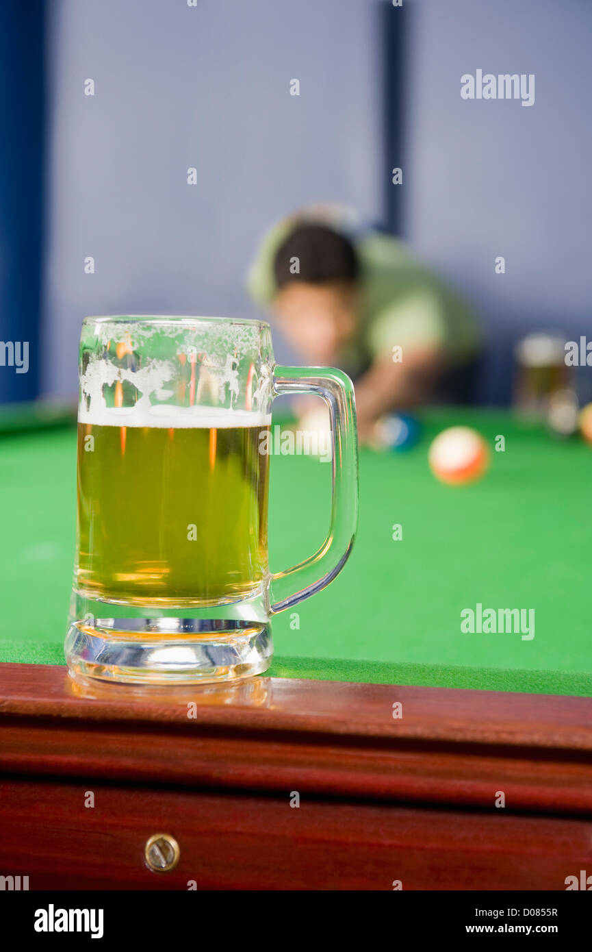 Young man playing pool and a beer glass kept on the pool table Stock ...