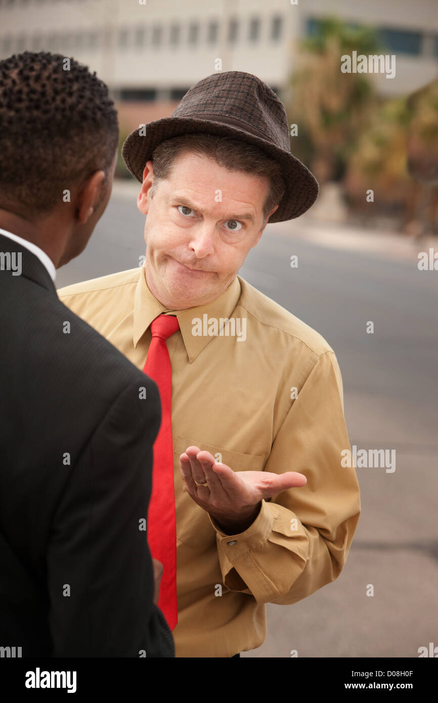 Caucasian businessman with open hand in front of African-American male ...