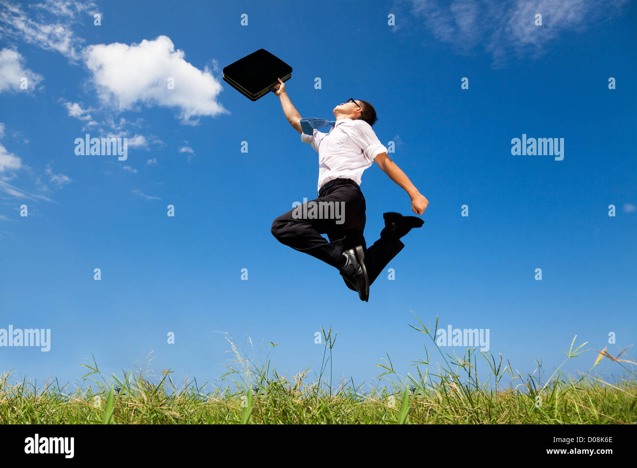 happy and successful businessman jumping on the field Stock Photo - Alamy