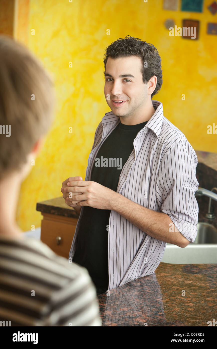 Two friends chit chat in kitchen a Stock Photo - Alamy