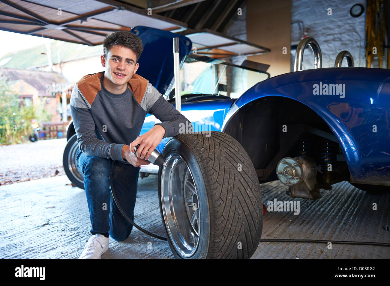 Teenage boy working on sports car in garage Stock Photo - Alamy